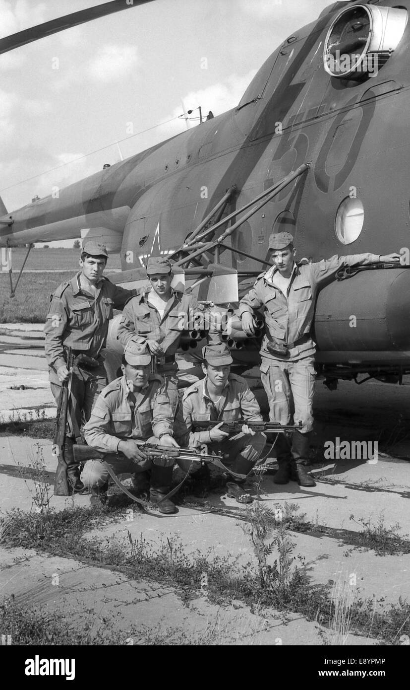 A squad of soldiers standing near a combat helicopter Mi-8. Film scan ...