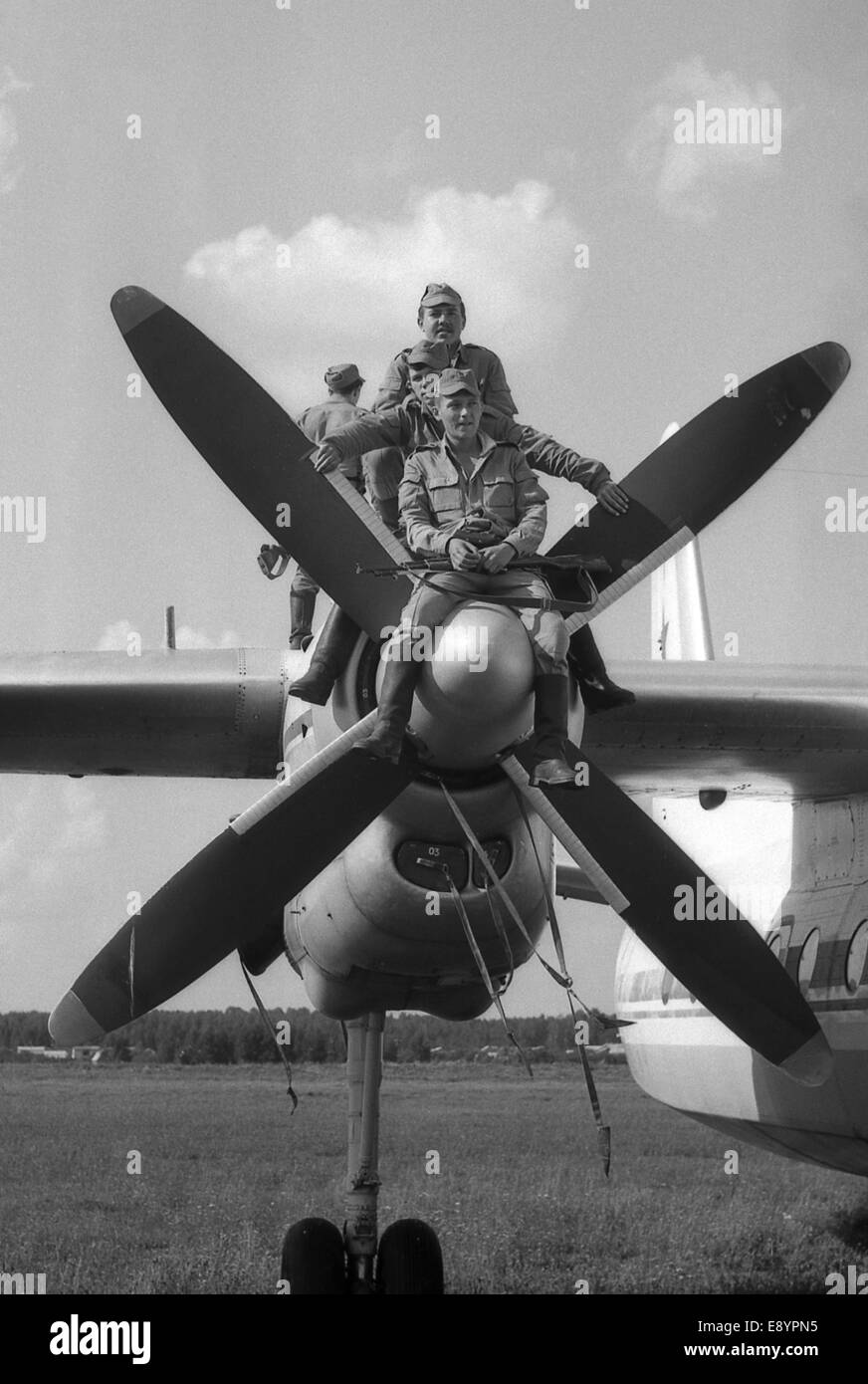 A group of soldiers standing on the wing of a military transport ...