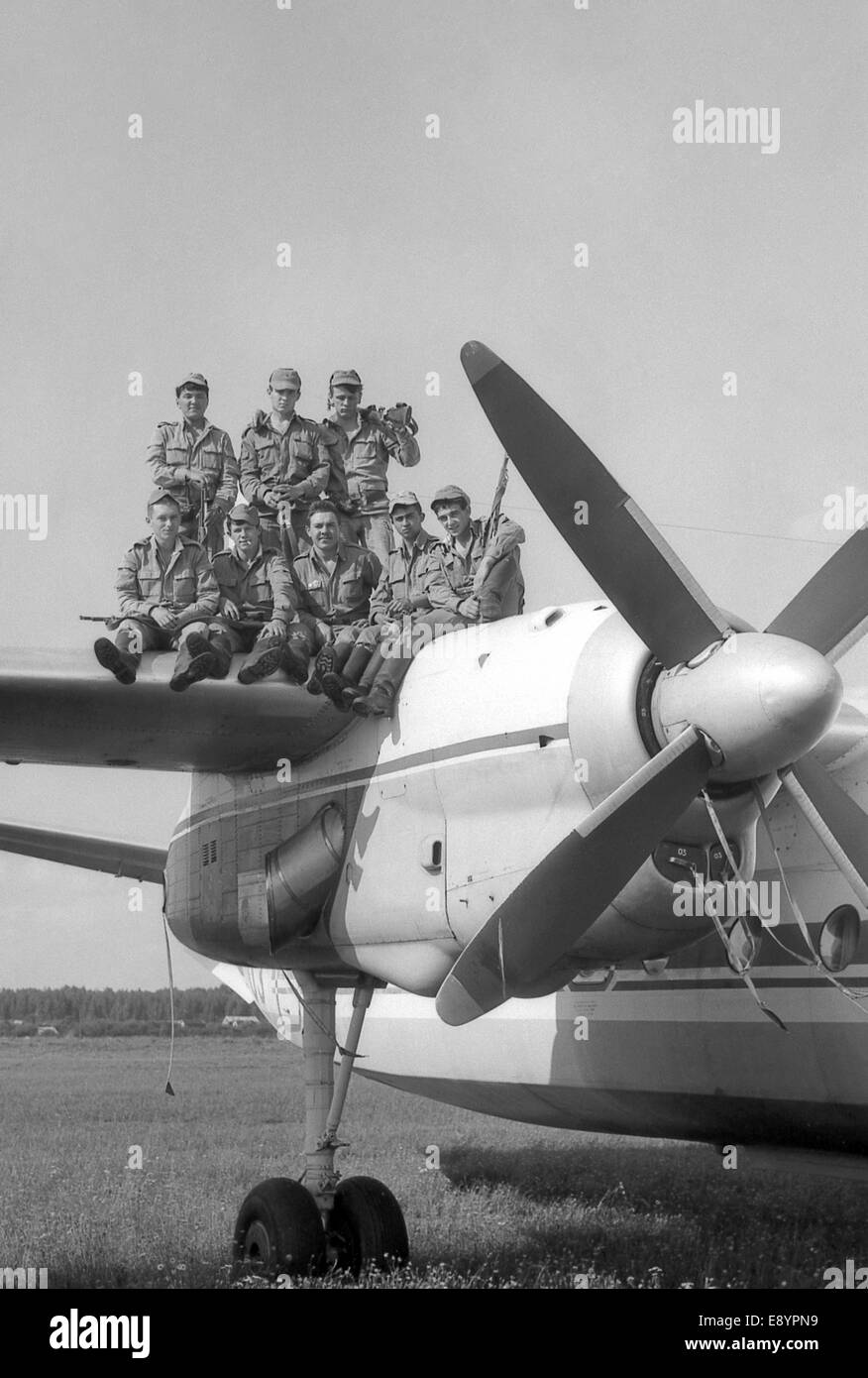 A group of soldiers standing on the wing of a military transport ...