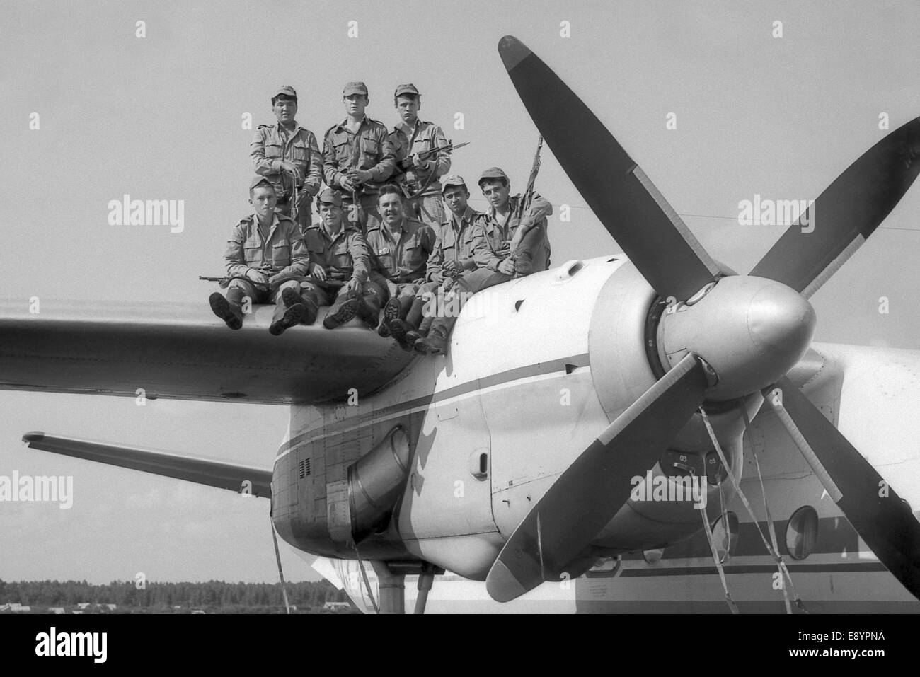 A group of soldiers standing on the wing of a military transport ...
