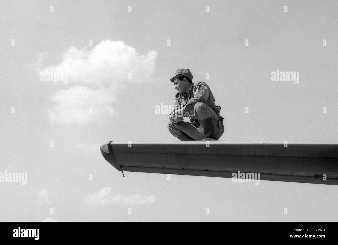 A soldier sitting on the wing of a military transport plane An-24. Film ...