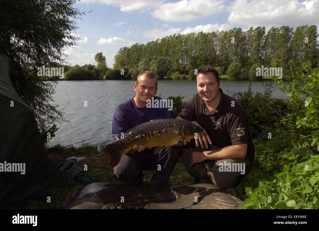 Men holding carp they've just caught on lake in Gloucestershire England ...