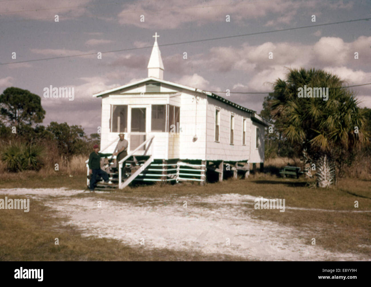 This photograph shows a church situated in a coconut village, with the ...