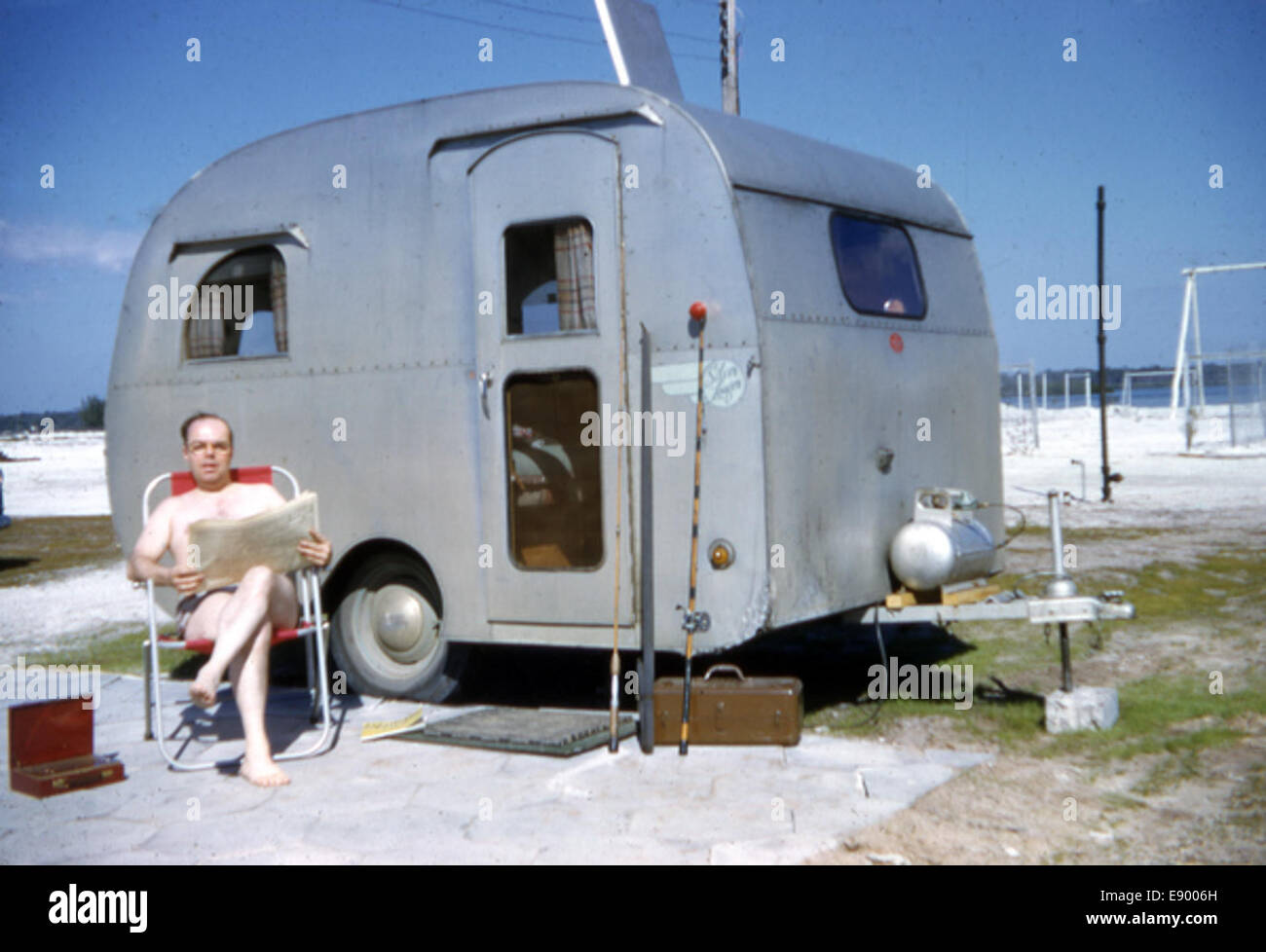 This photograph shows a person seated near their travel trailer at St ...