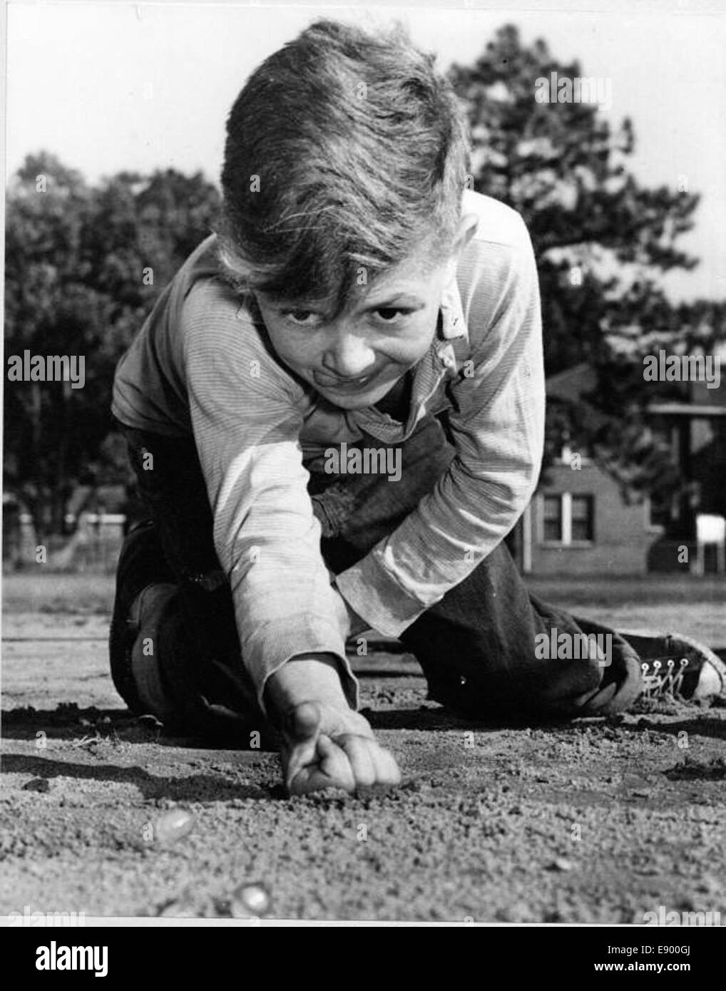 This photograph captures a young boy playing marbles in Jacksonville ...