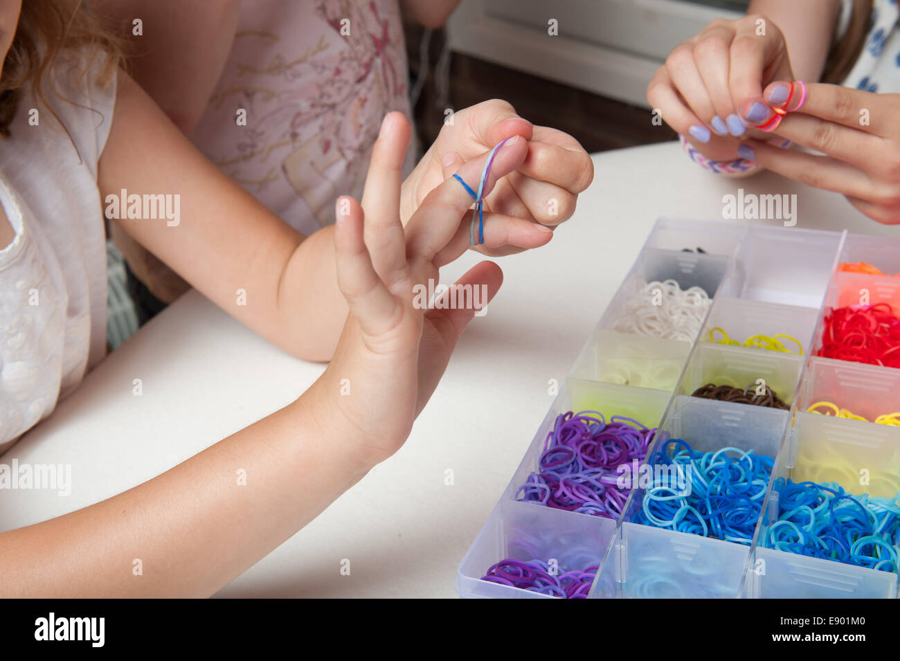 Young girl playing with loom bands on her fingures Stock Photo - Alamy
