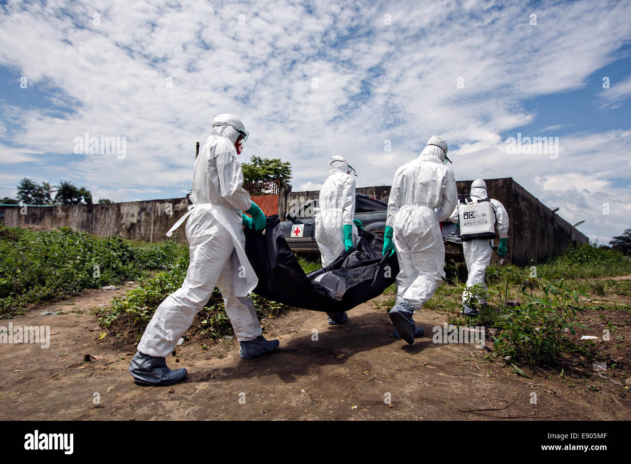 Healthcare volunteers known as burial boys remove the corpse of an ...