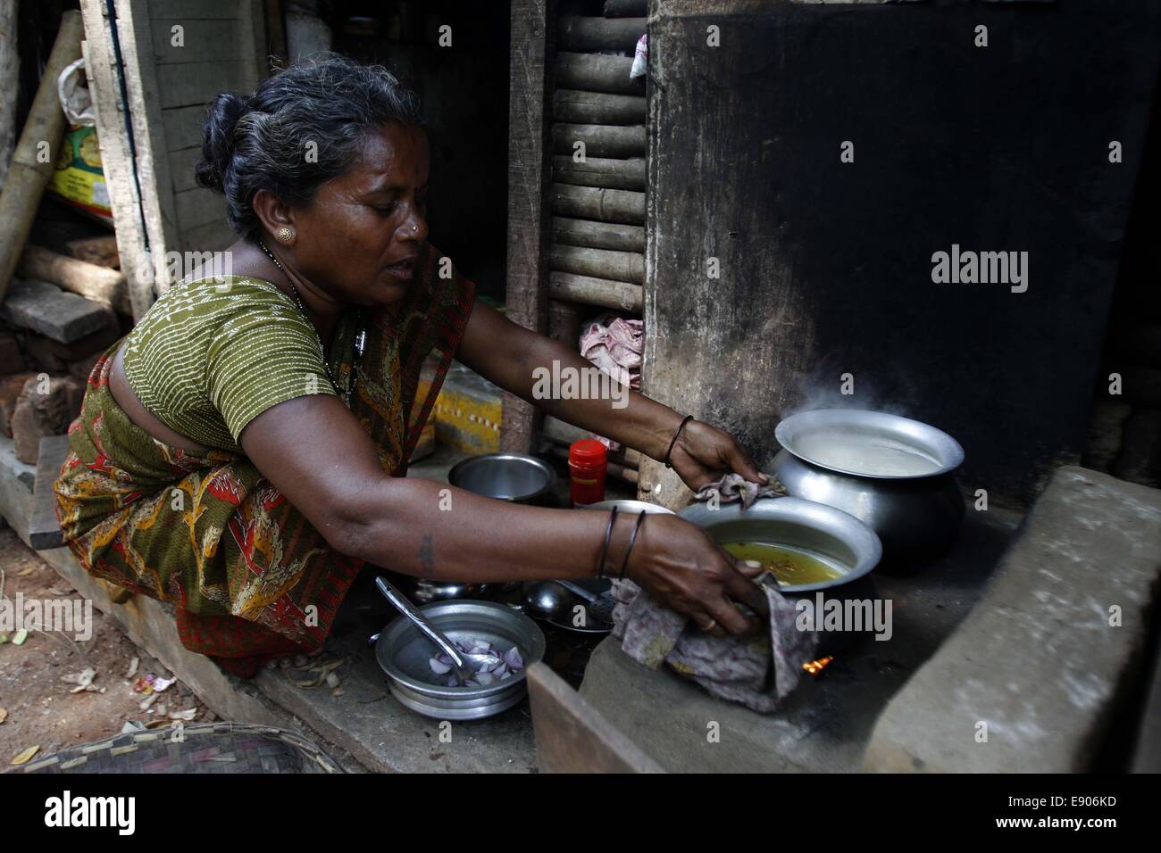 Bhubaneswar, India. 16th Oct, 2014. A slum woman cooks for her family ...