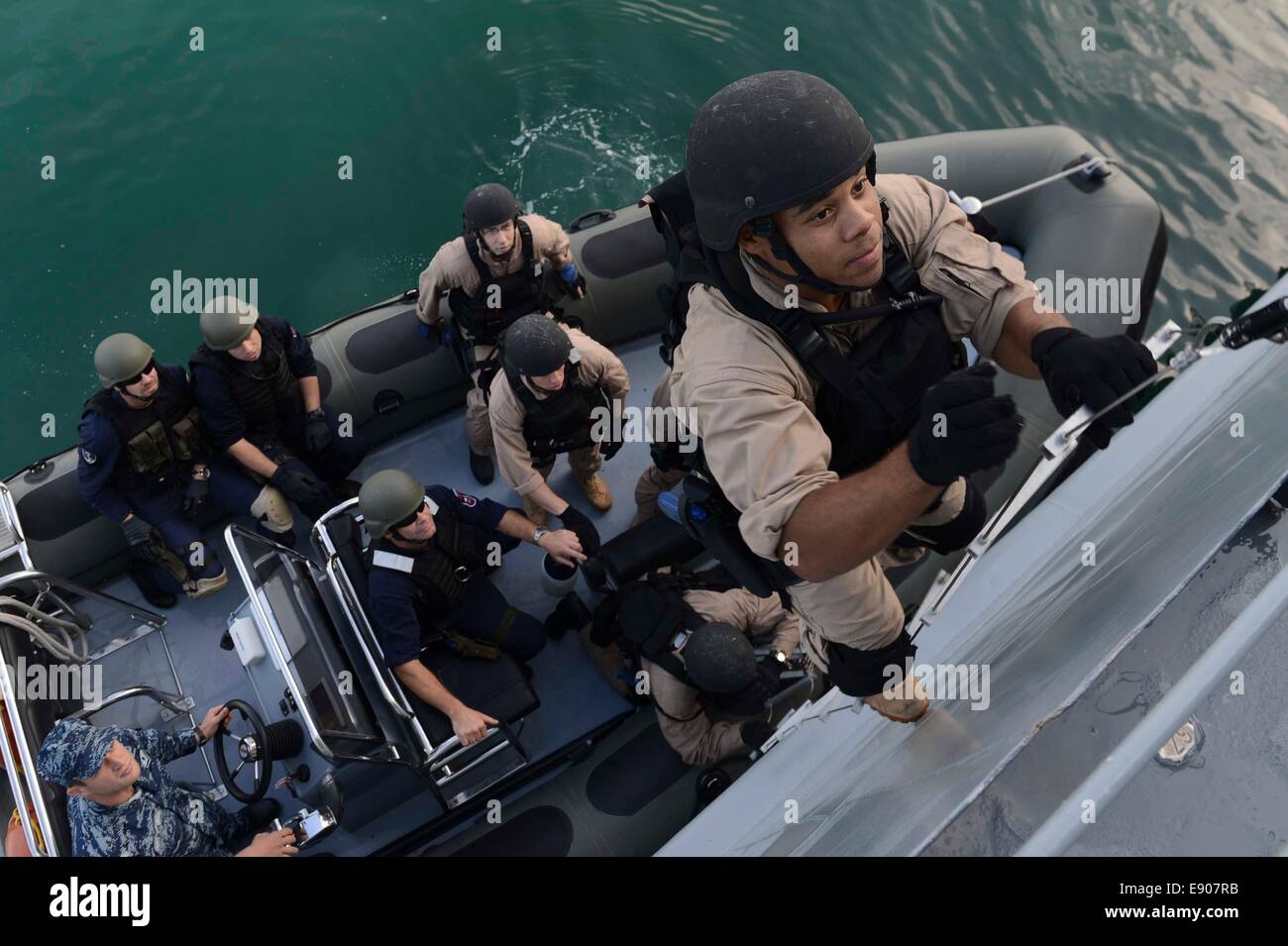 U.S. Navy Gunner's Mate 2nd Class Phillip Wright, foreground, assigned ...