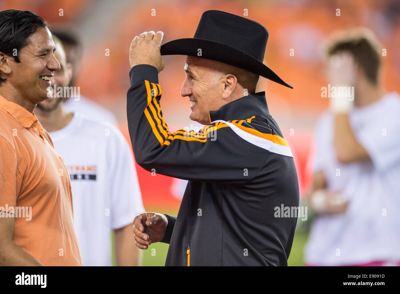 Houston, Texas, USA. 16th Oct, 2014. Brian Ching gives a cowboy hat to ...