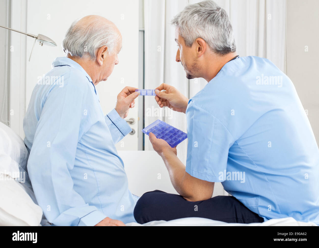 Caretaker Guiding Prescription To Senior Man Stock Photo - Alamy