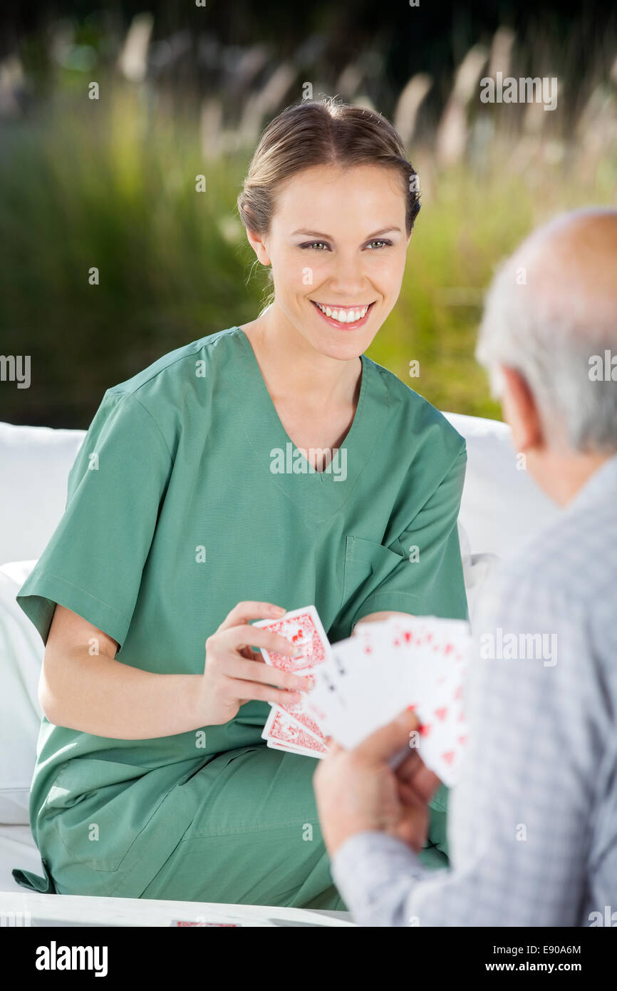 Beautiful Female Nurse Playing Cards With Senior Man Stock Photo - Alamy