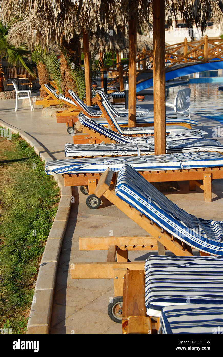 Folding chairs row by swimming pool Stock Photo - Alamy