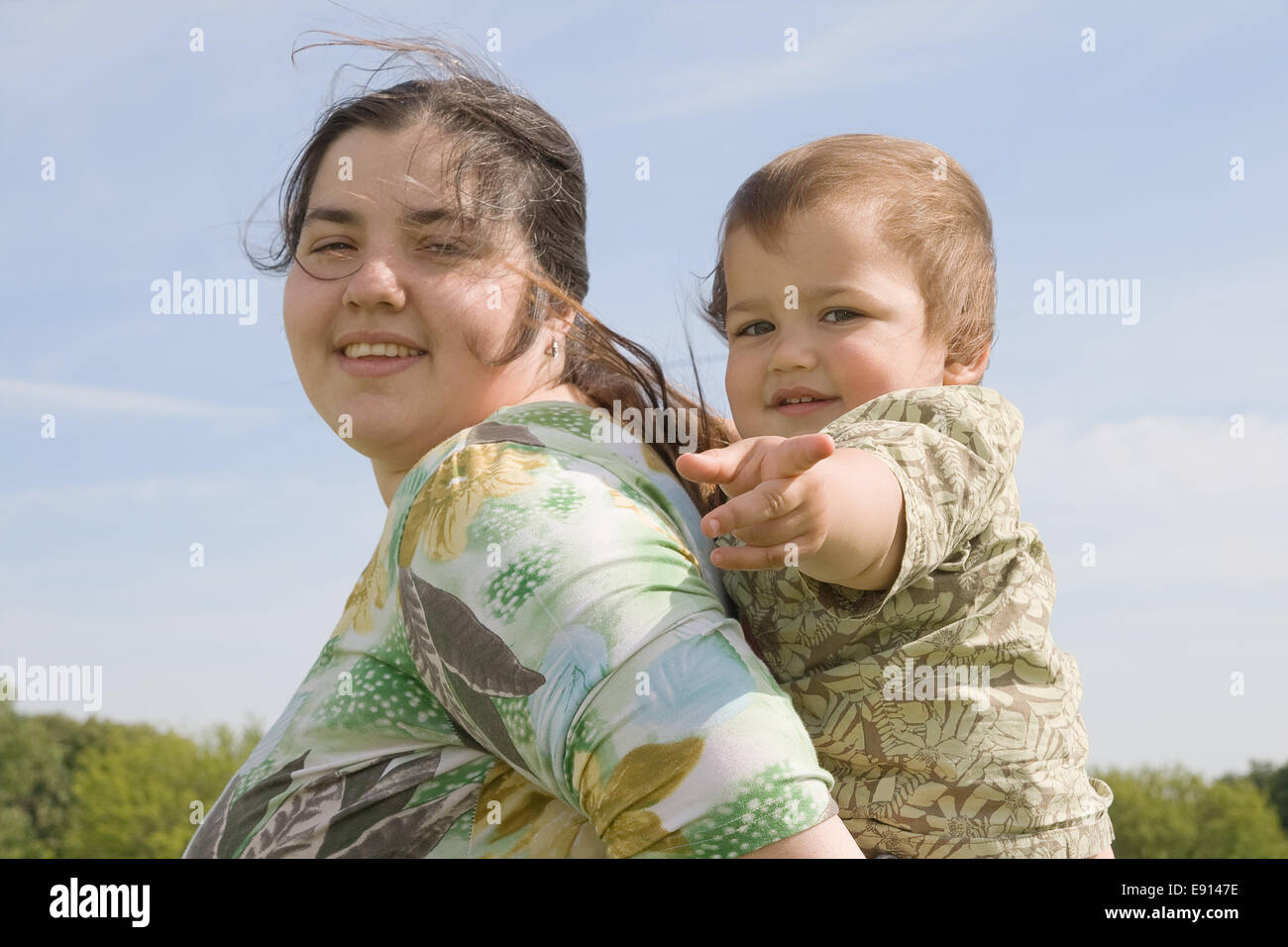 Woman holding her little child on back Stock Photo - Alamy