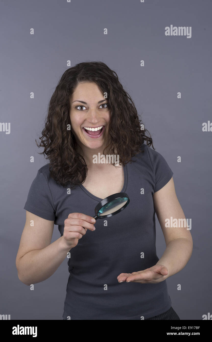 Magnifying glass in front of the face Stock Photo - Alamy