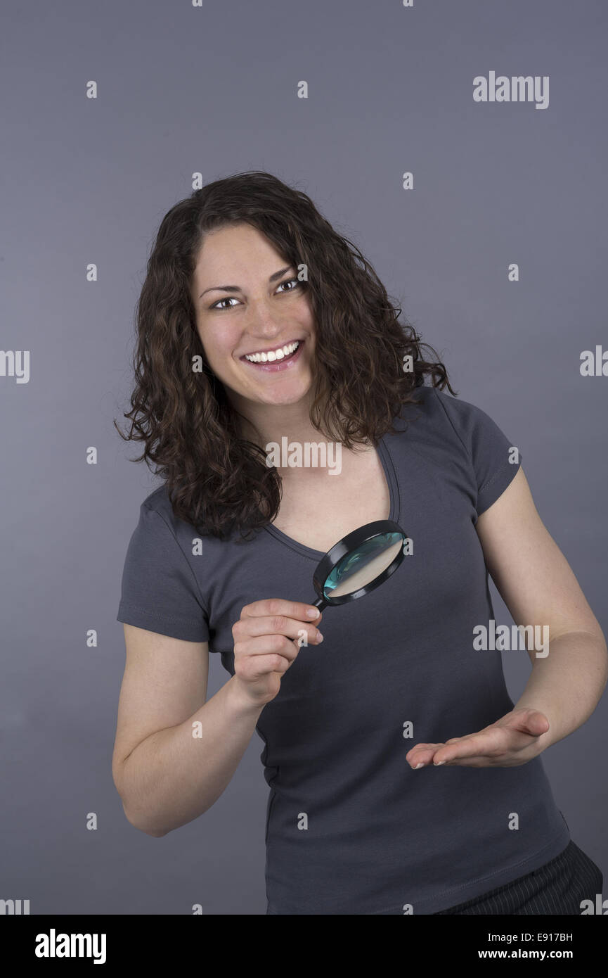 Magnifying glass in front of the face Stock Photo - Alamy