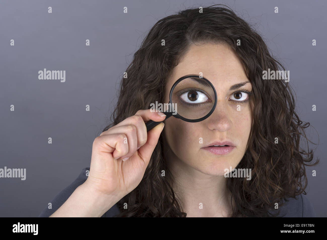 Magnifying glass in front of the face Stock Photo - Alamy