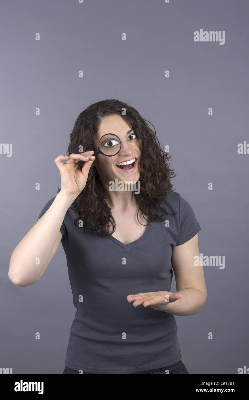 Magnifying glass in front of the face Stock Photo - Alamy