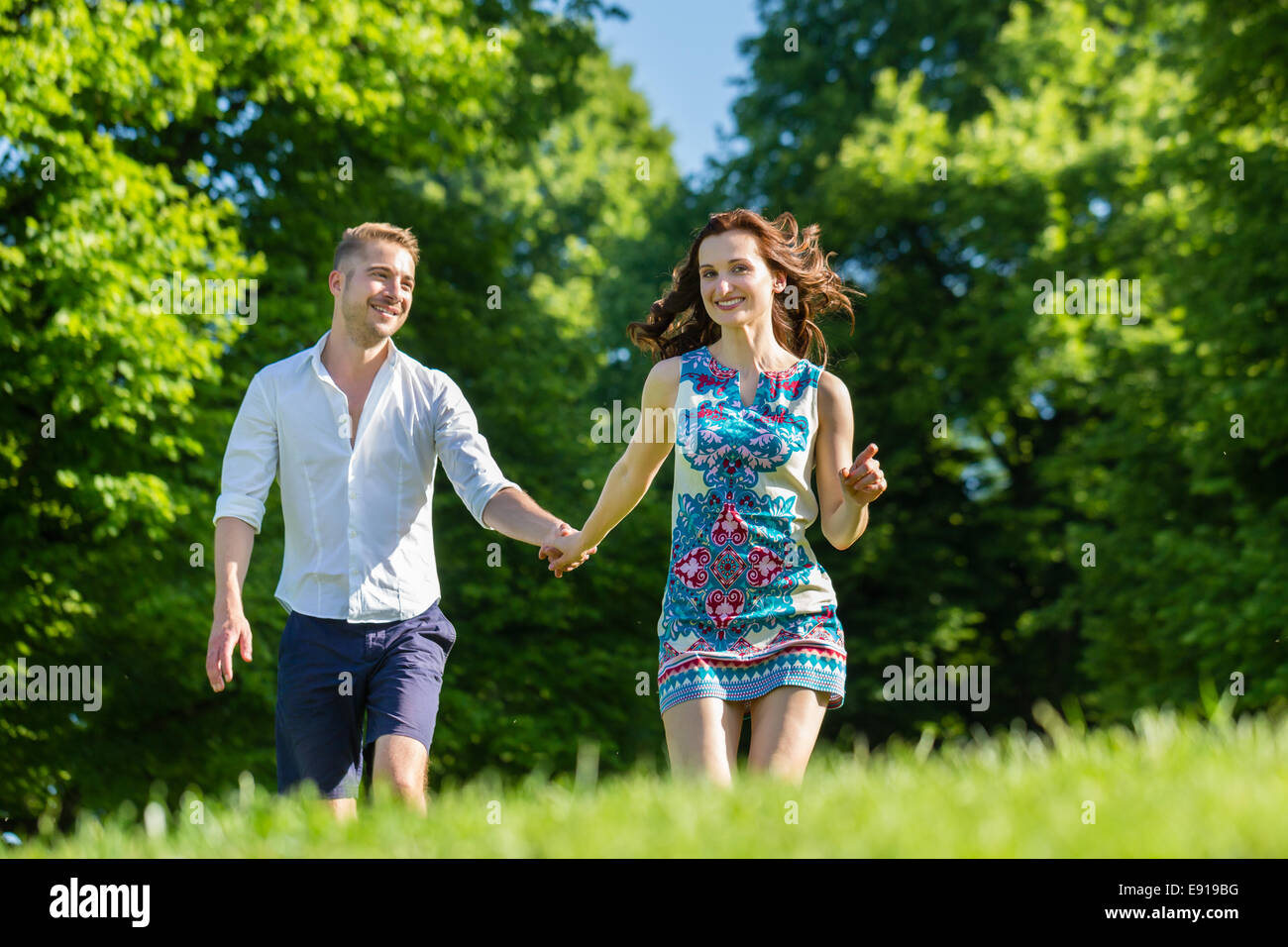 Couple in love running through park Stock Photo - Alamy