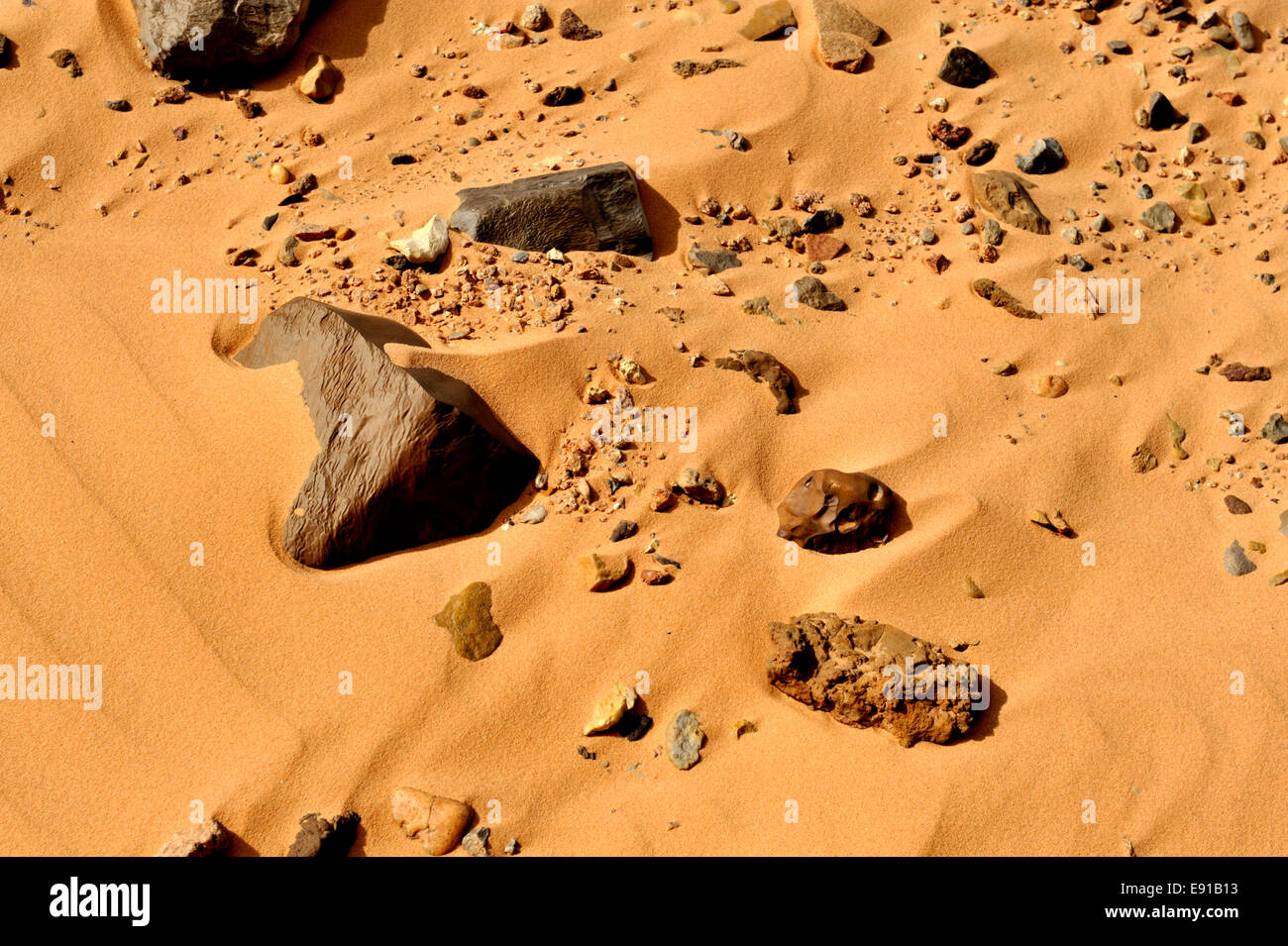 Rocks in wind blown desert sands Stock Photo - Alamy