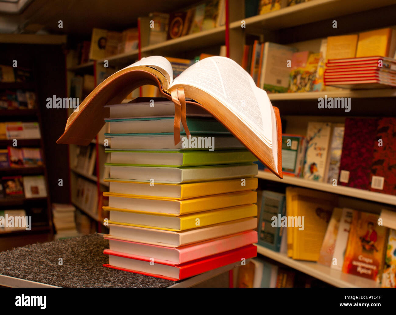 Open book on the stack of colorful books Stock Photo - Alamy