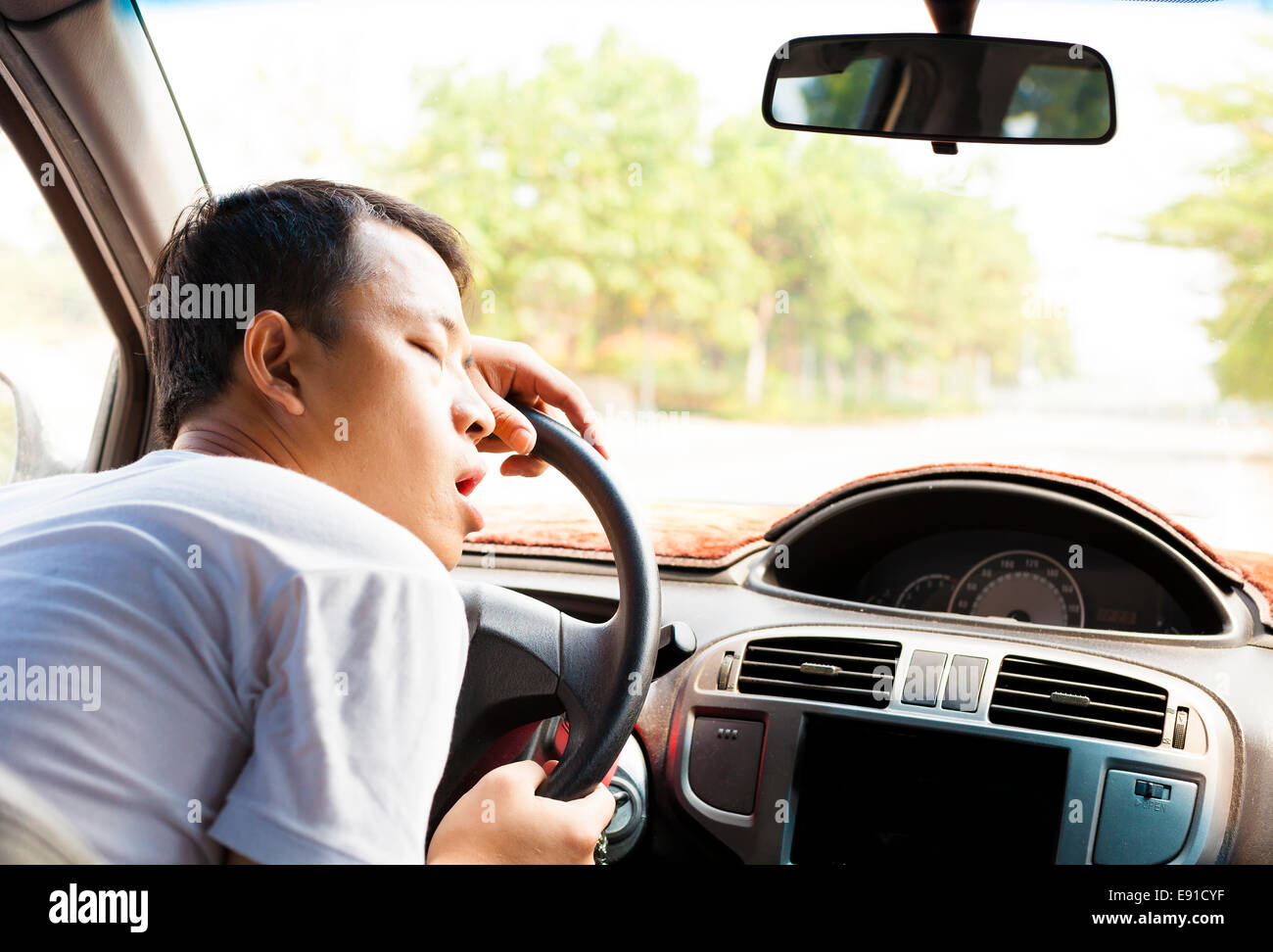 Exhausted driver resting on steering wheel in the car Stock Photo - Alamy