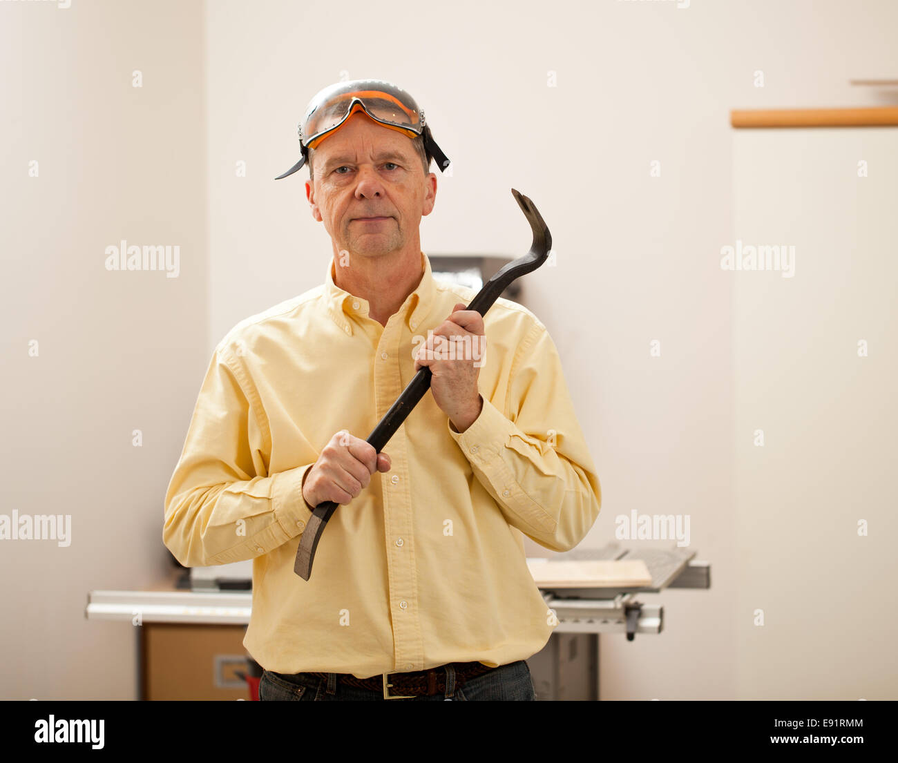 Senior man holding a crowbar Stock Photo - Alamy