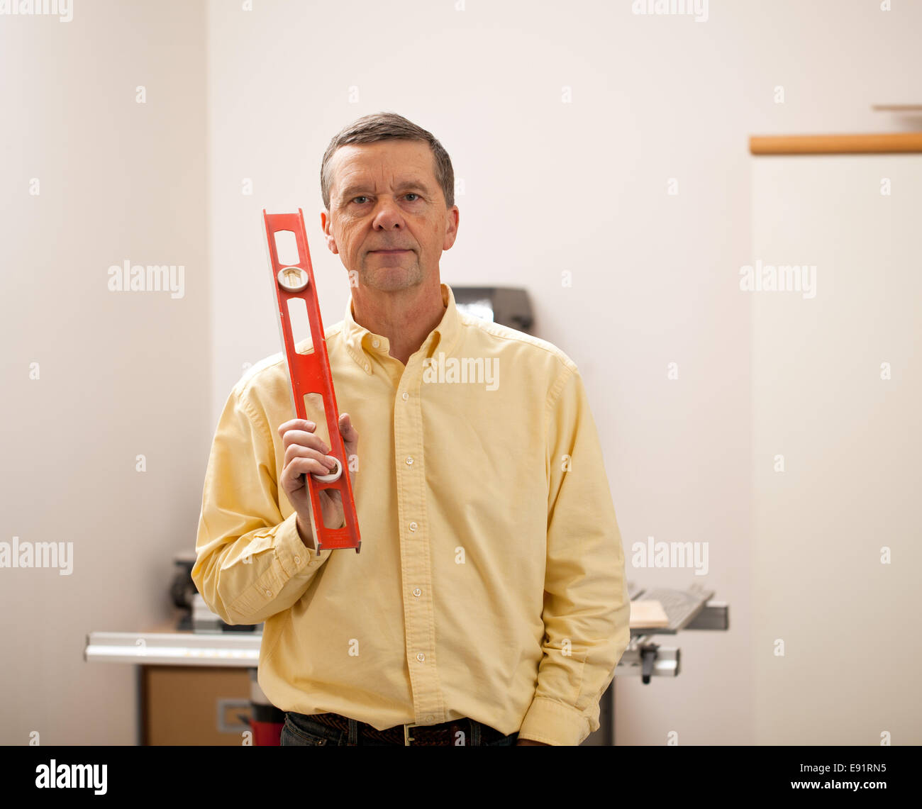 Senior man holding level Stock Photo - Alamy