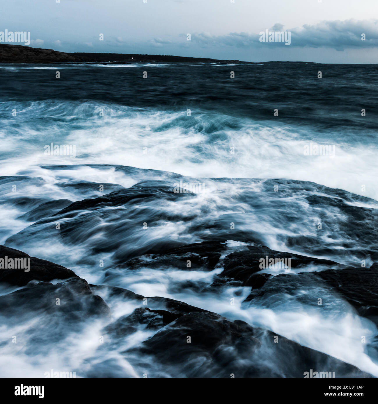 Frothing waves rush over rocks Stock Photo - Alamy