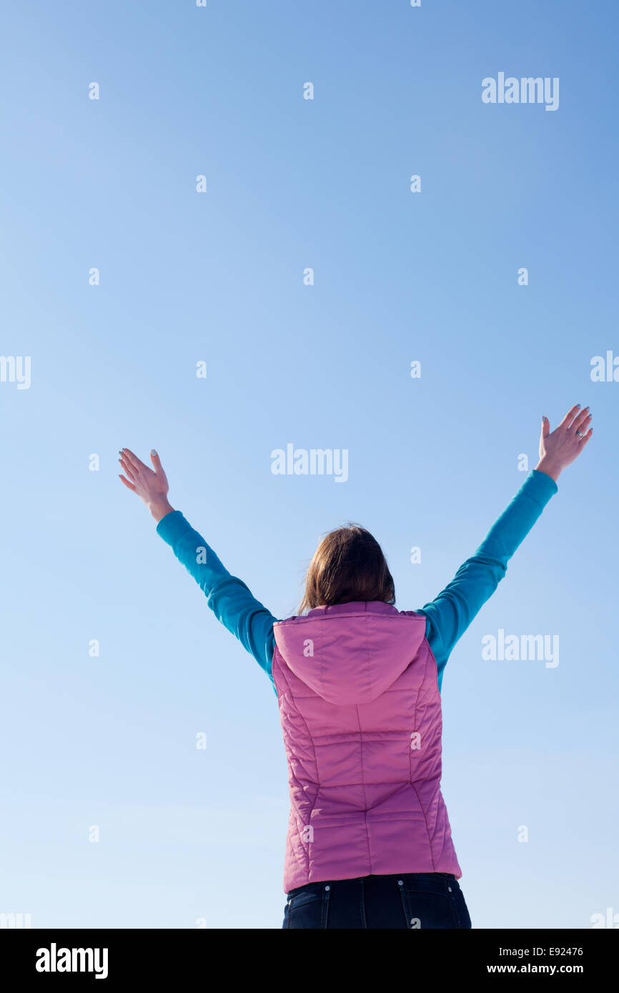 Teen girl staying with raised hands Stock Photo - Alamy