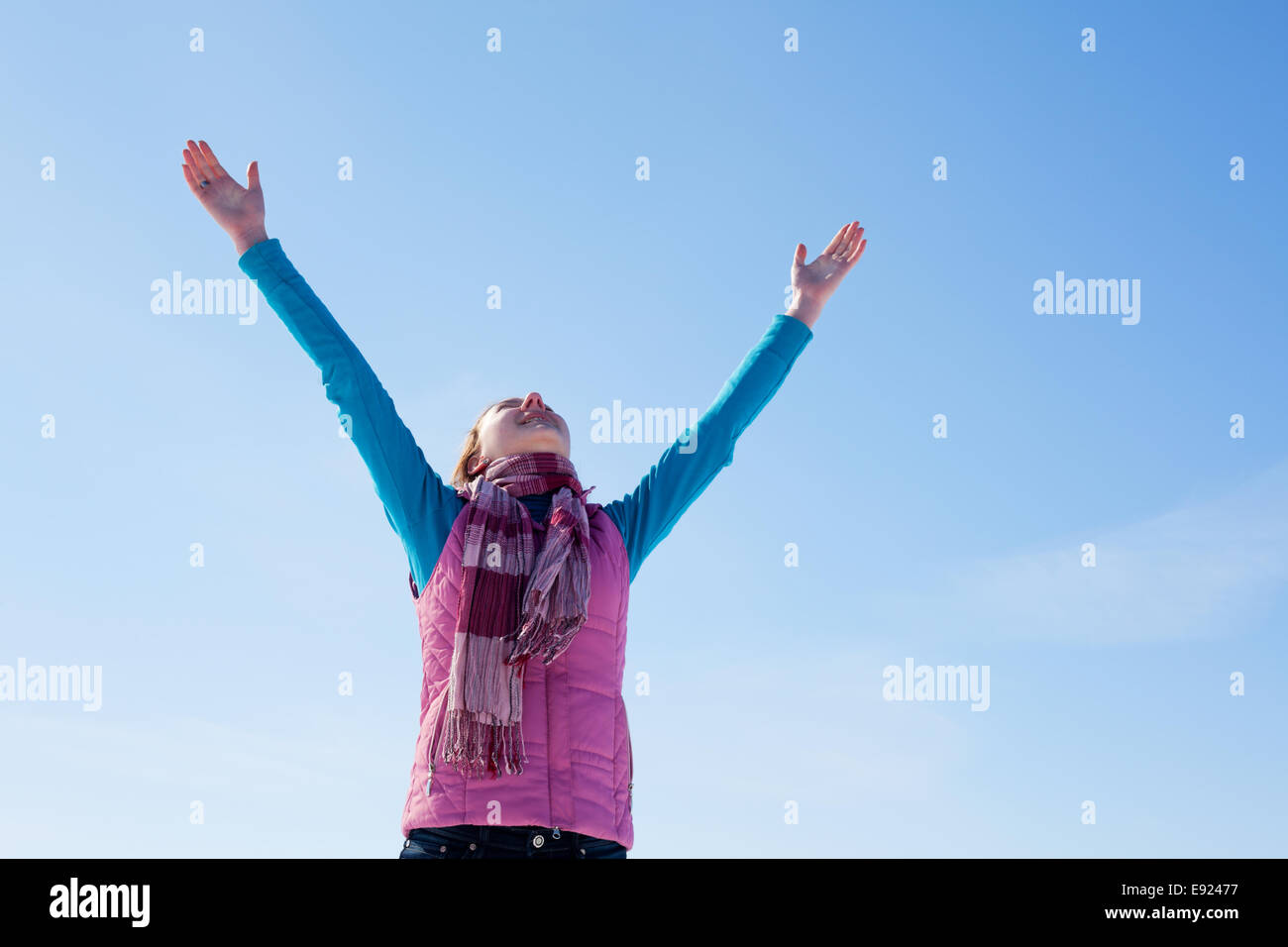 Teen girl staying with raised hands Stock Photo - Alamy
