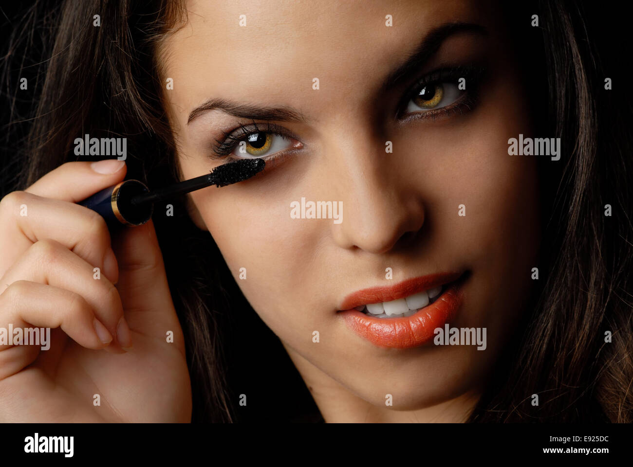 Pretty lady doing makeup using eyelash brush Stock Photo - Alamy