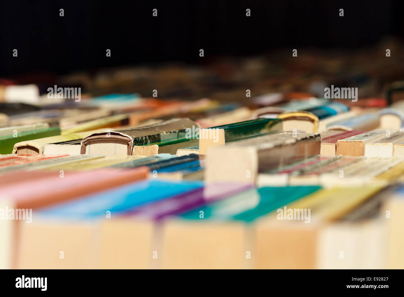 Colorful old books lined up for sale in a flea market Stock Photo - Alamy