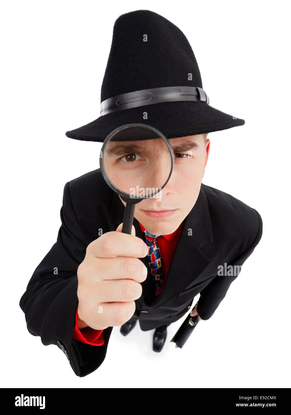 Wide angle top view of a young detective, looking up through magnifier ...