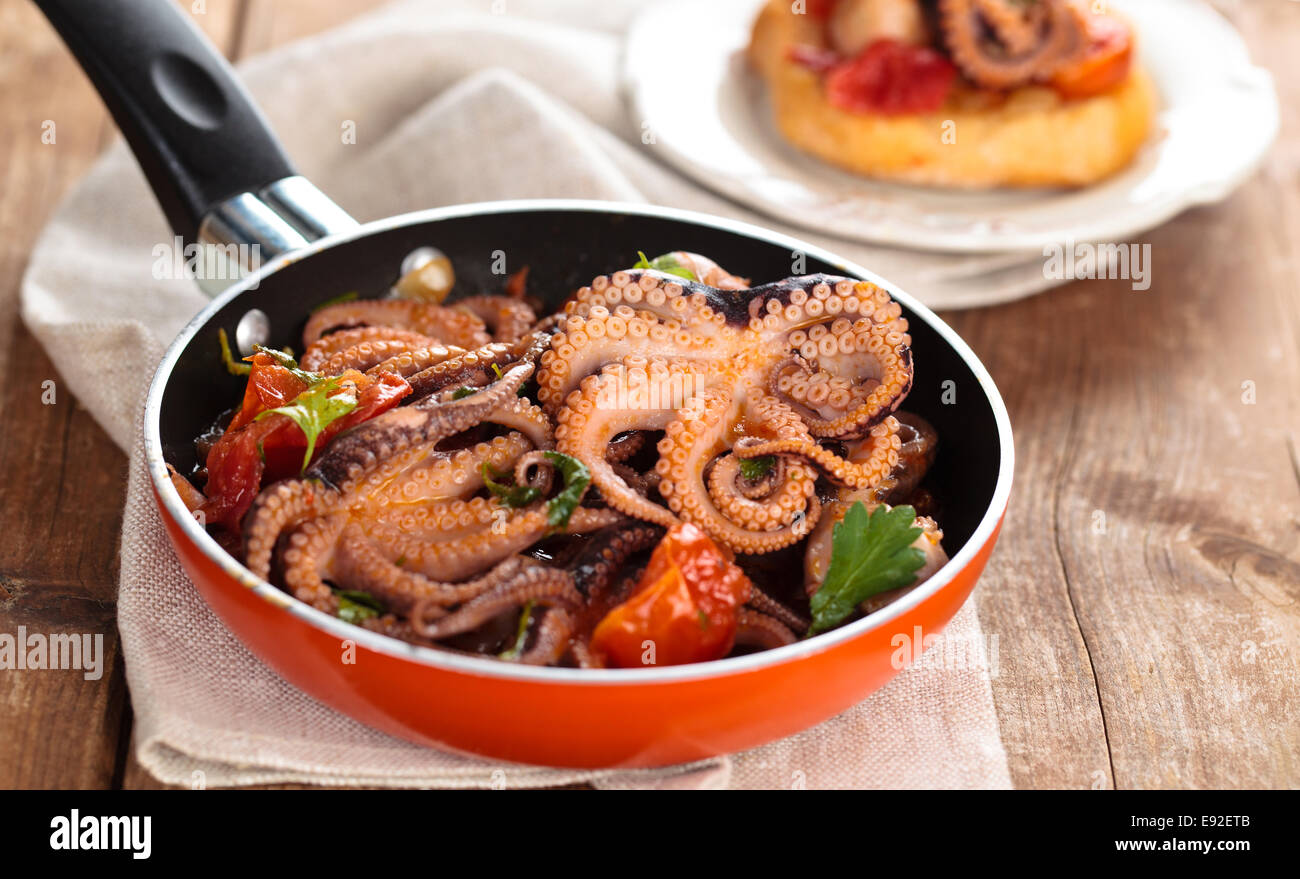 Italian food. Baby octopuses prepared with tomatoes, garlic and parsley ...