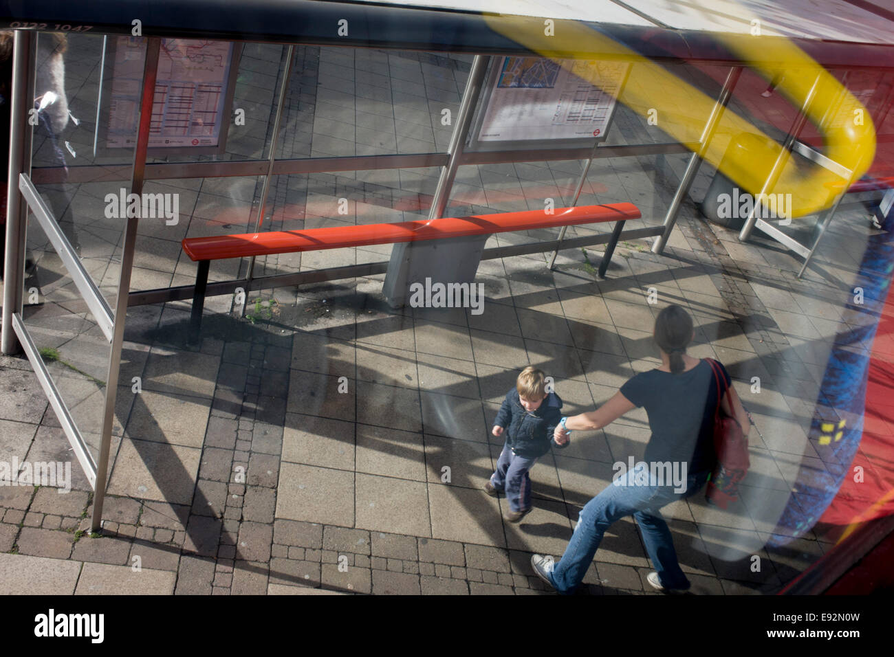Mother and active child with aerial view of bus stop shadows and ...