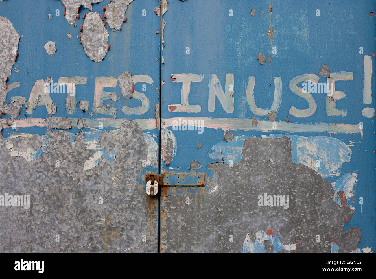 A 'Gates in Use' sign on peeling barri in south London Stock Photo - Alamy