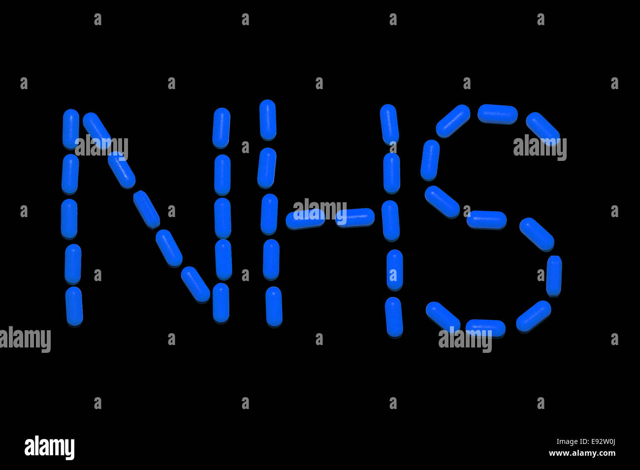 An image of the word NHS made from blue medical pills against a black ...