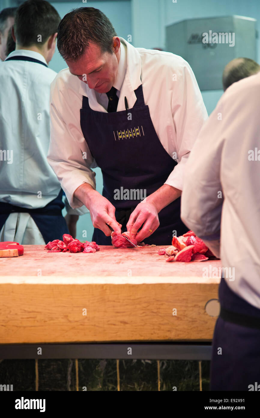 A butcher cutting meat at the counter Stock Photo - Alamy