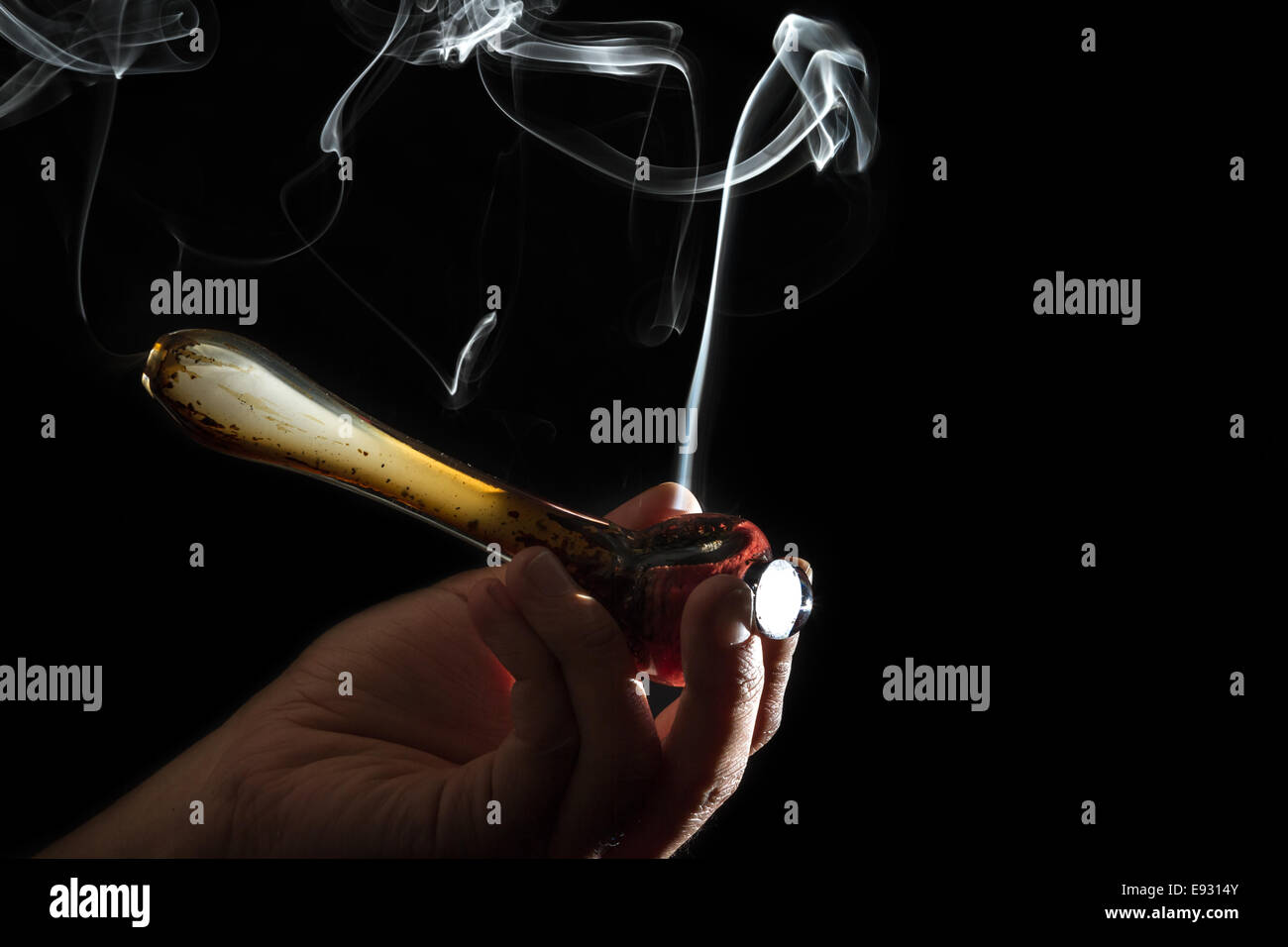 high contrast studio shoot of a pipe with simulated marijuana smoke on ...