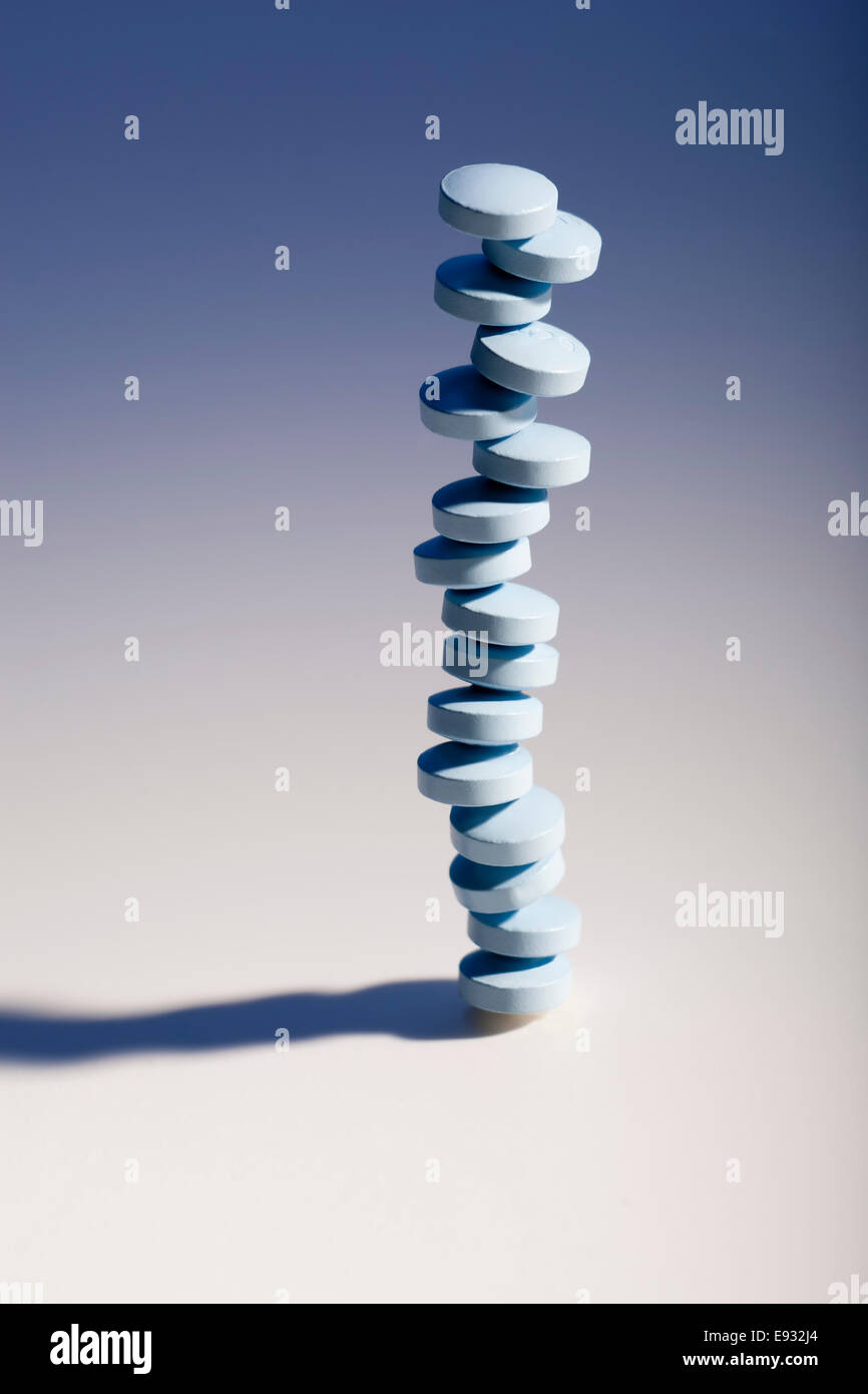 Stack of blue prescription pills ready to fall over. Spotlight effect ...