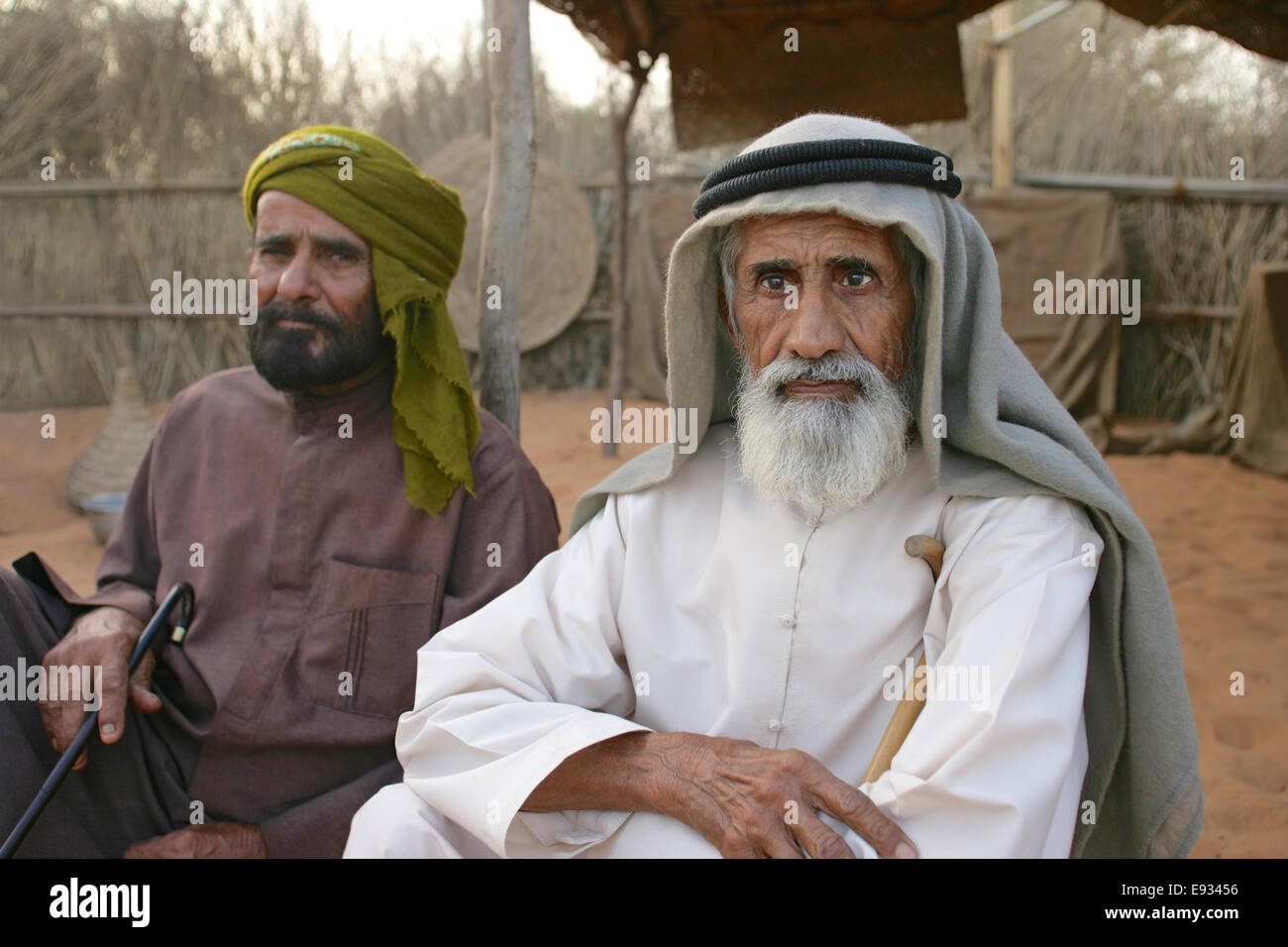 Two Arab men in traditional dress at their camp near Dubai. The older ...