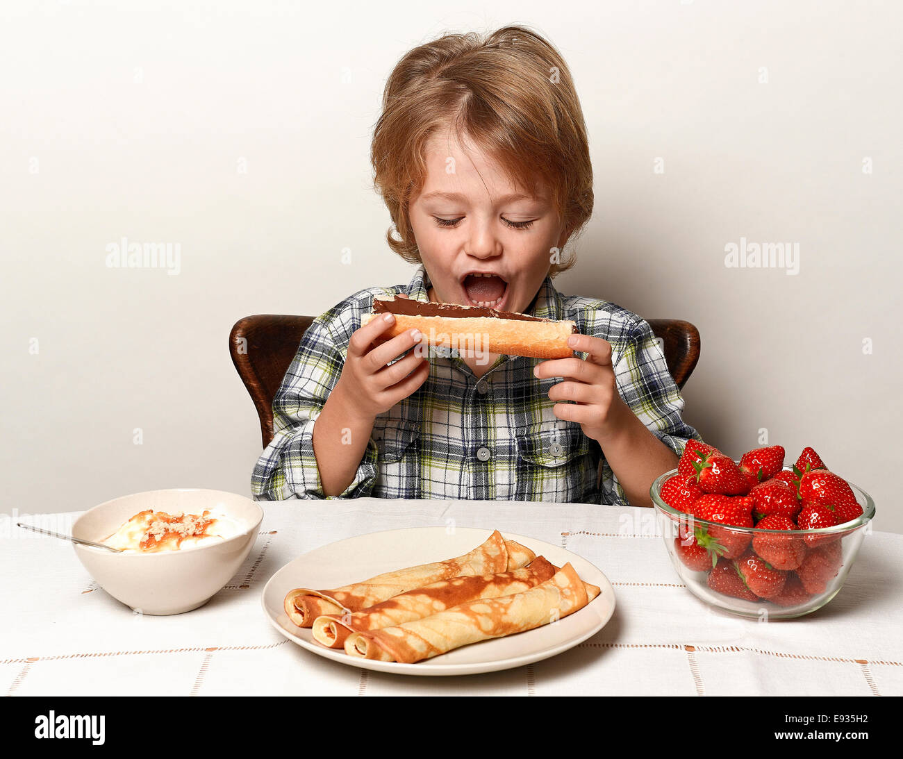 Happy boy eating bread with chocolate on white background Stock Photo ...