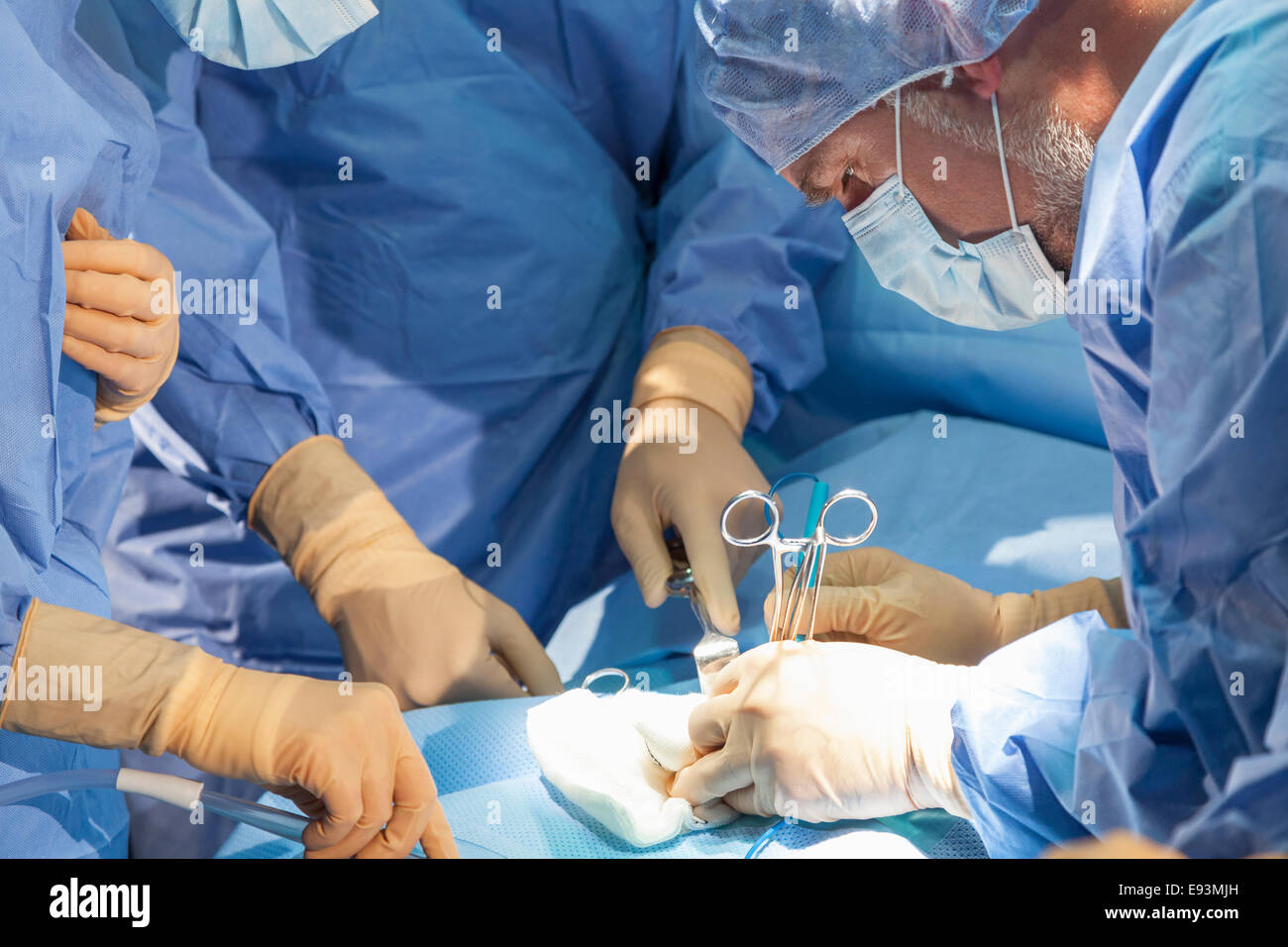 A team of medical doctors and male surgeon in surgery operating on a ...