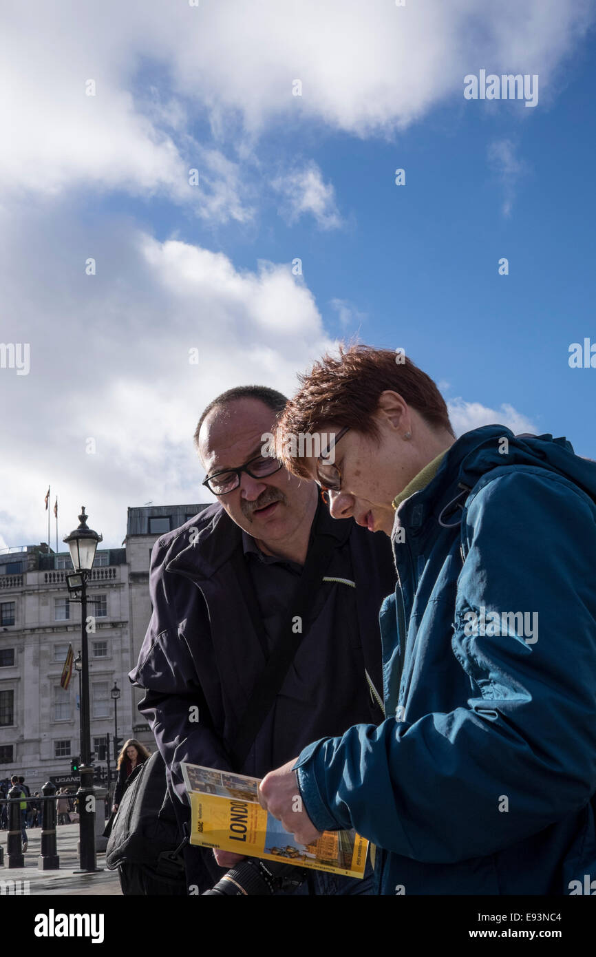 Tourists reading London travel guide in Trafalgar Square Stock Photo ...