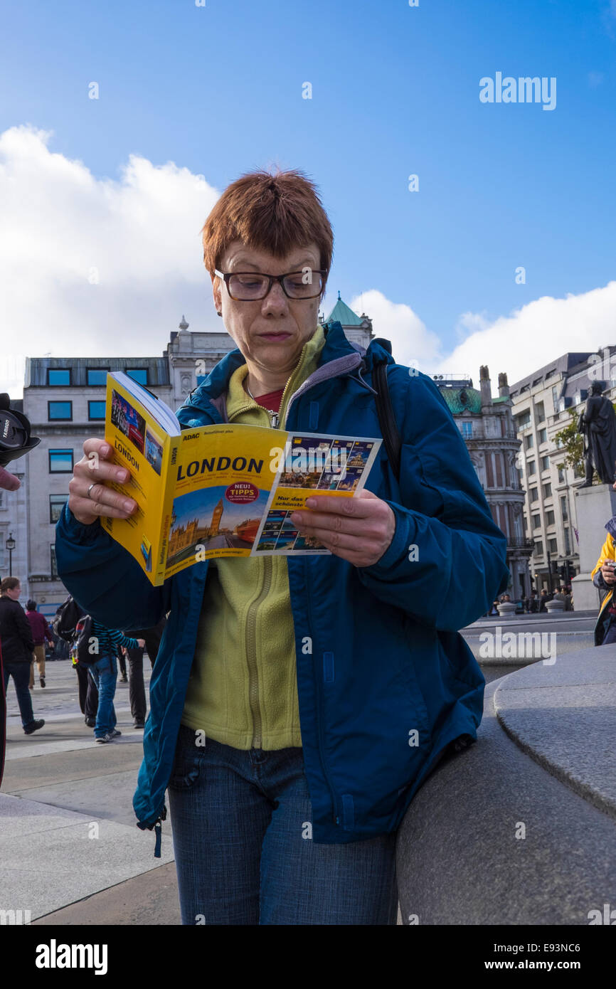Tourists reading London travel guide in Trafalgar Square Stock Photo ...