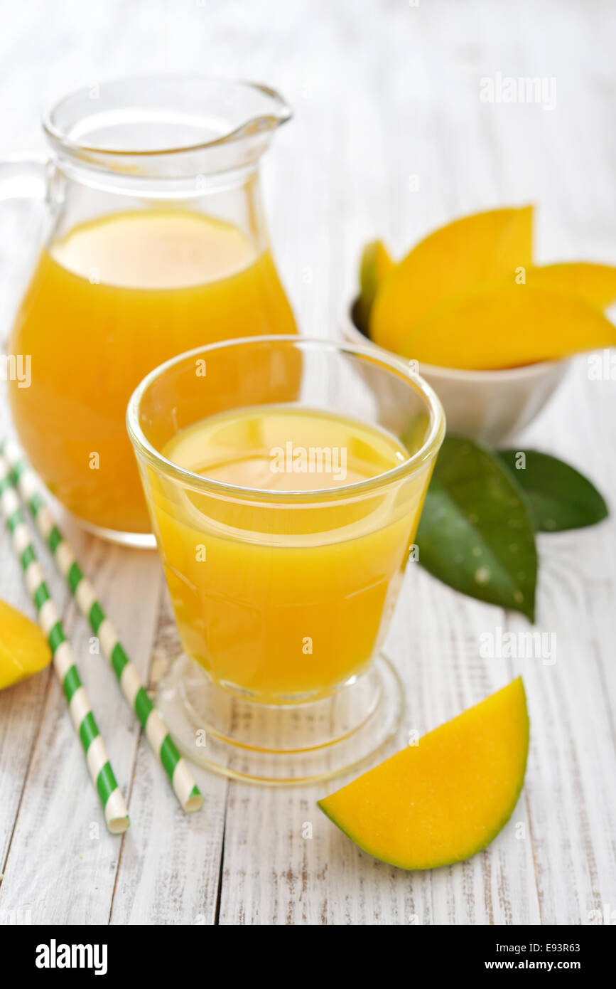 Mango juice in a glass on wooden white background Stock Photo - Alamy