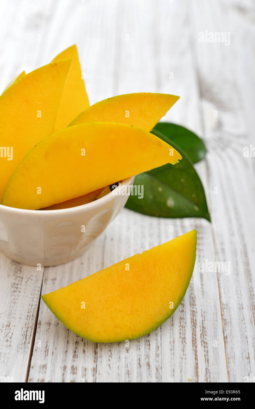 Ripe fresh mango slices in bowl on wooden white background Stock Photo ...