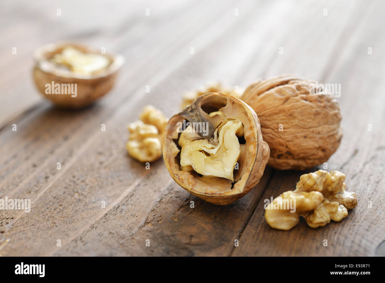 Walnut kernels and whole walnuts on rustic old wooden background Stock ...