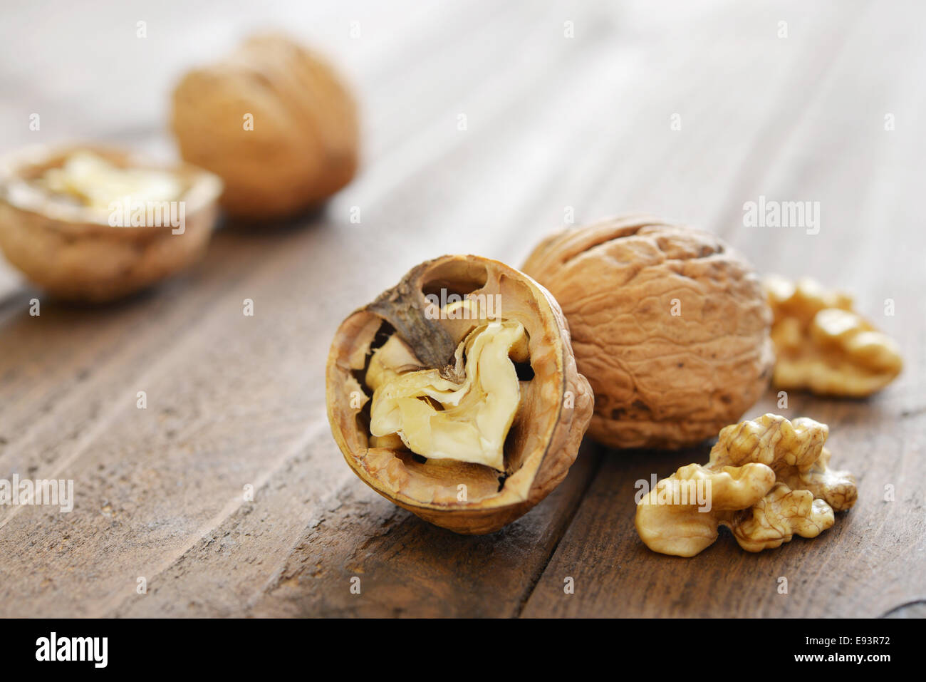 Walnut kernels and whole walnuts on rustic old wooden background Stock ...